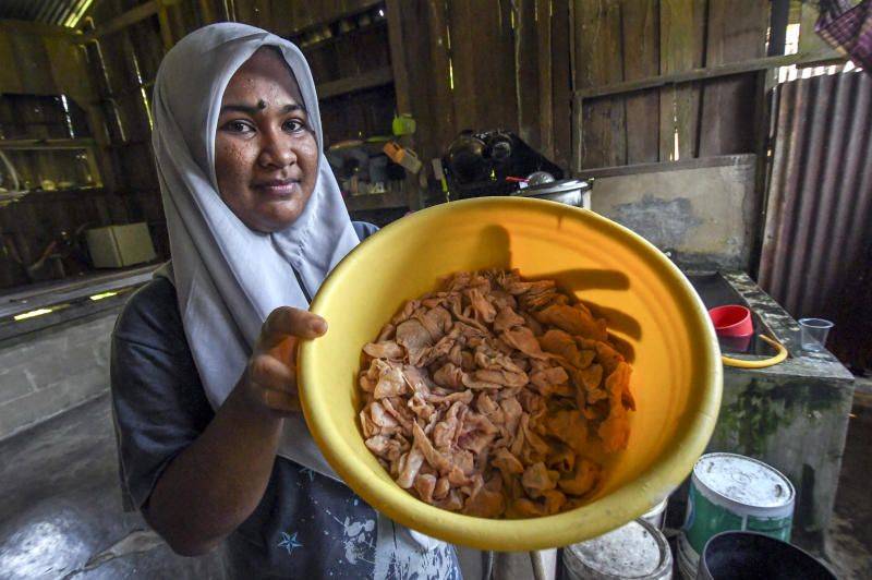 Poverty forces family to scavenge for discarded chicken skin to turn ...