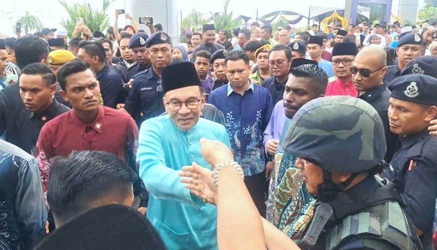 Anwar signs autographs, meets with visitors at Madani Raya event in ...