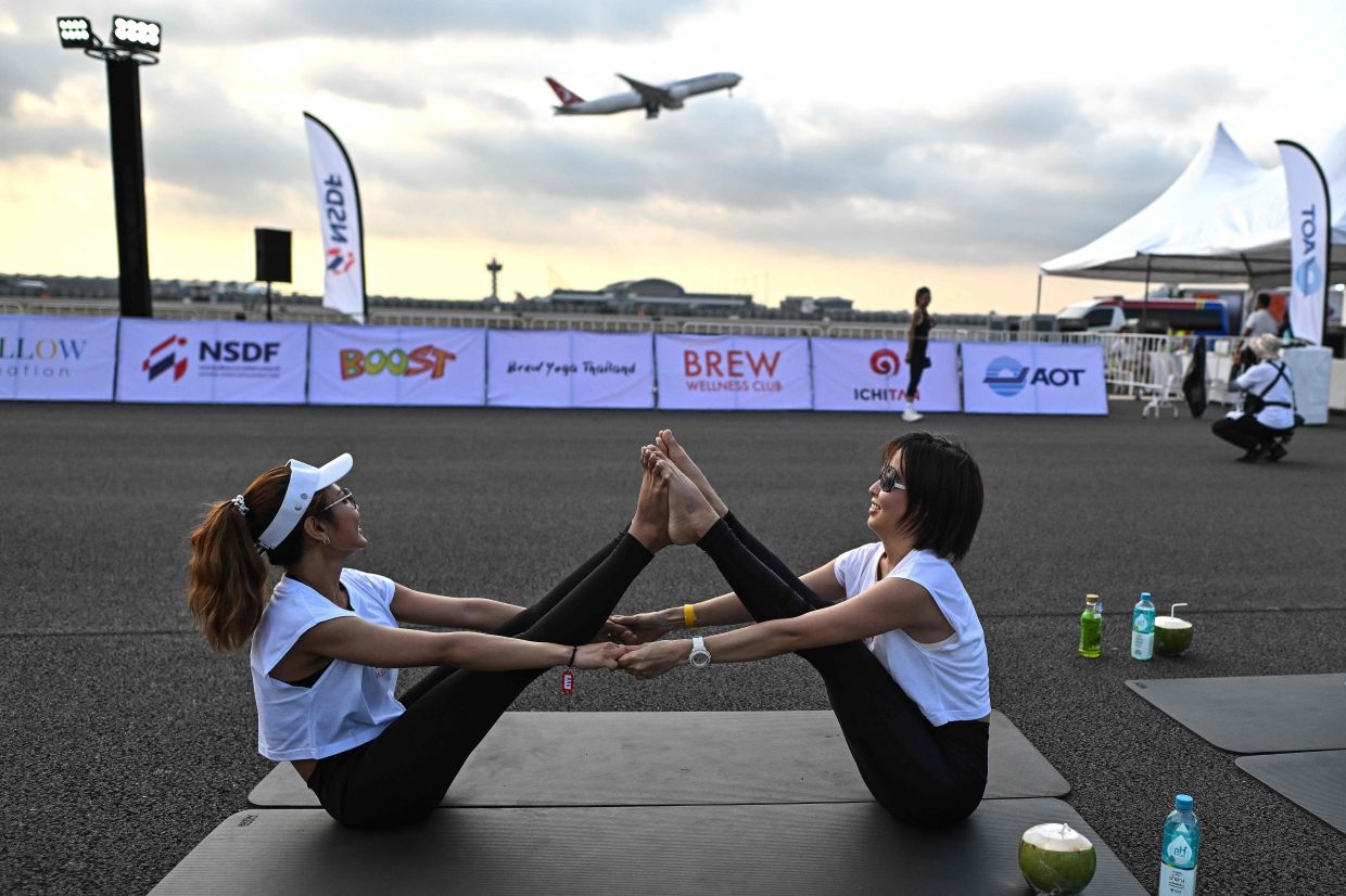 Hundreds take part in mass yoga on airport runway | The Star