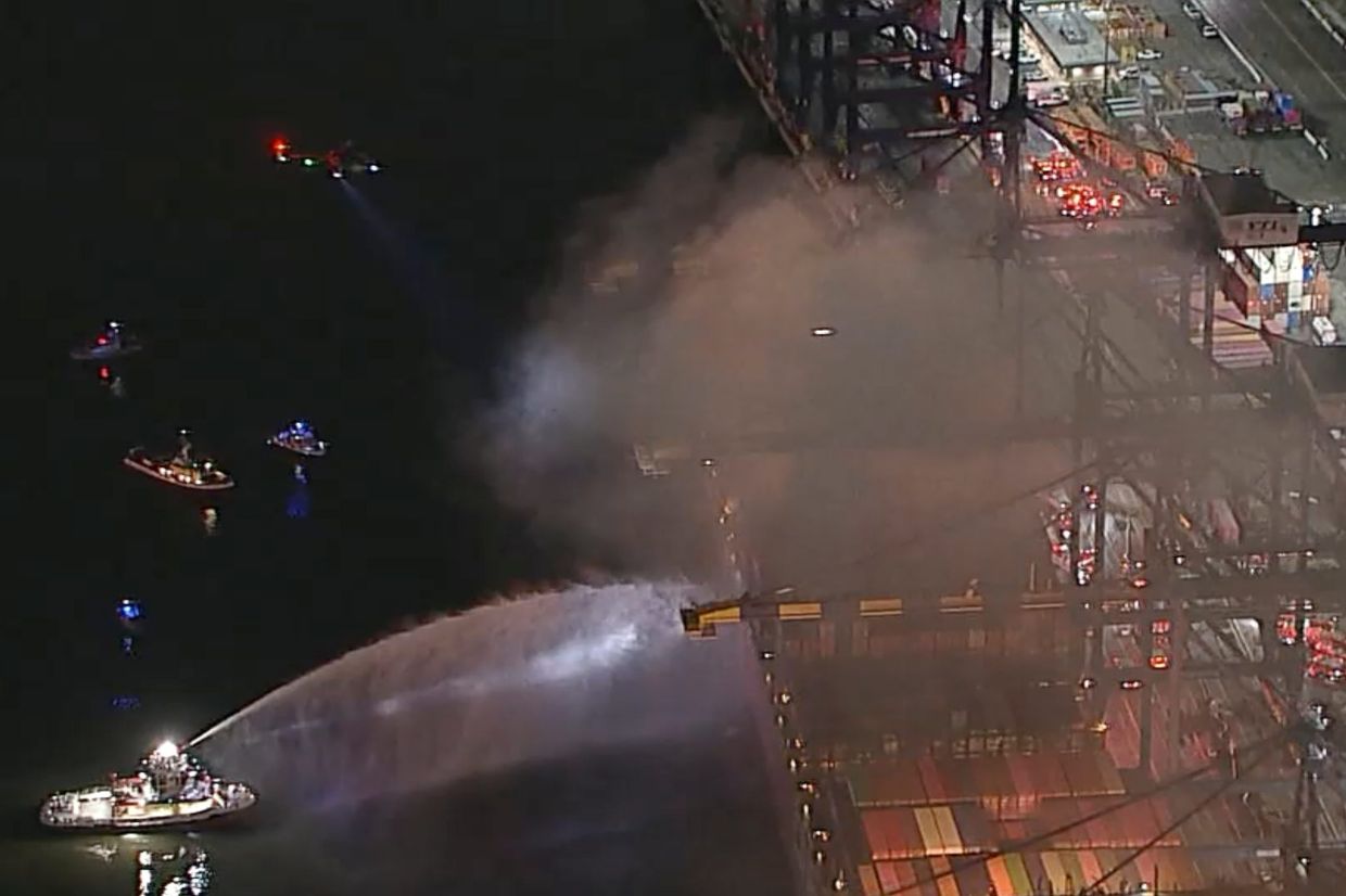 Dozens of firefighters battle blaze on container ship belonging to a ...